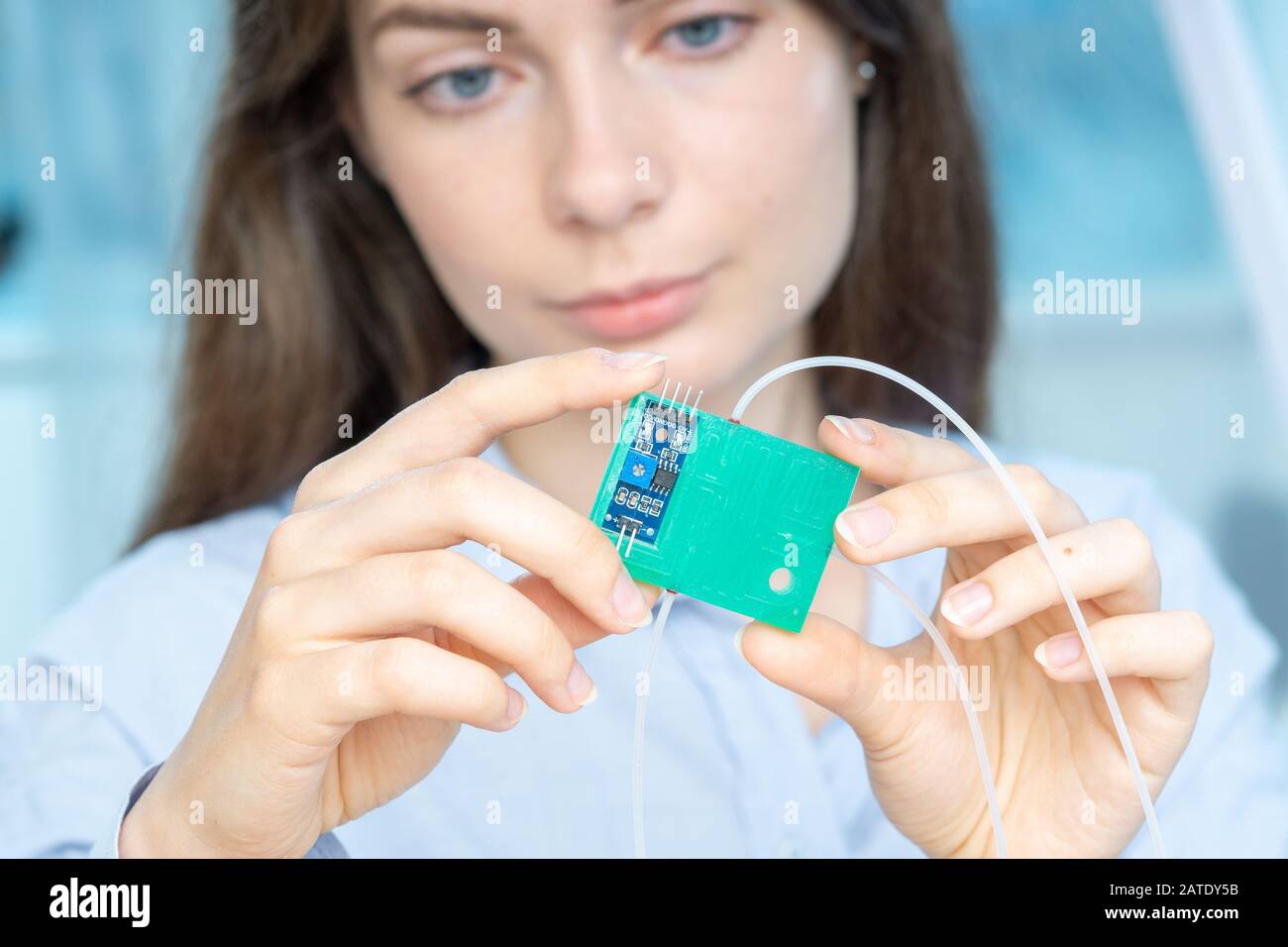 Young scientist woman in microbiological lab with lab-on-chip LOC ...