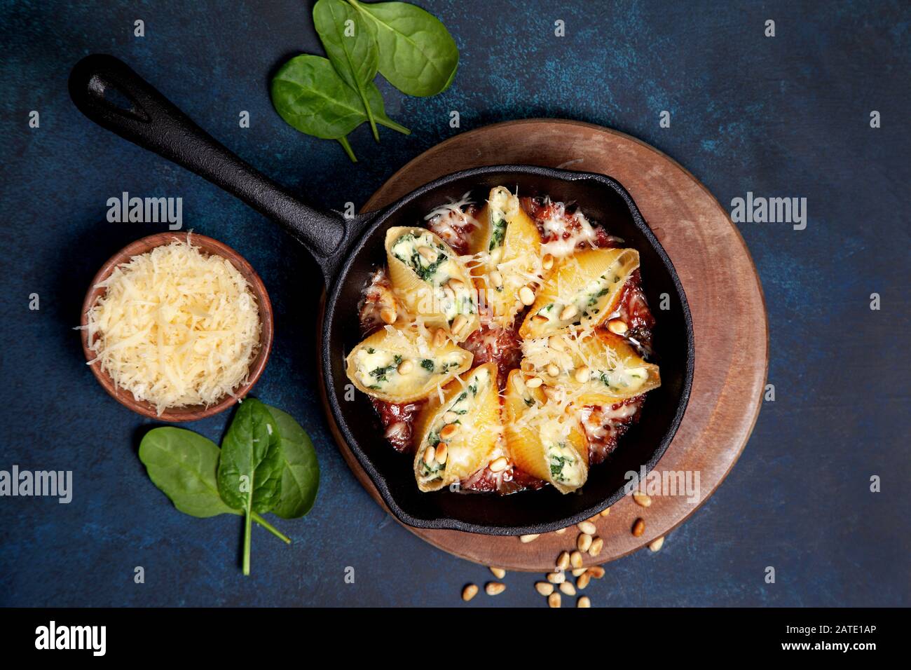 Stuffed pasta shells with spinach and ricotta in a cast iron pan on a ...
