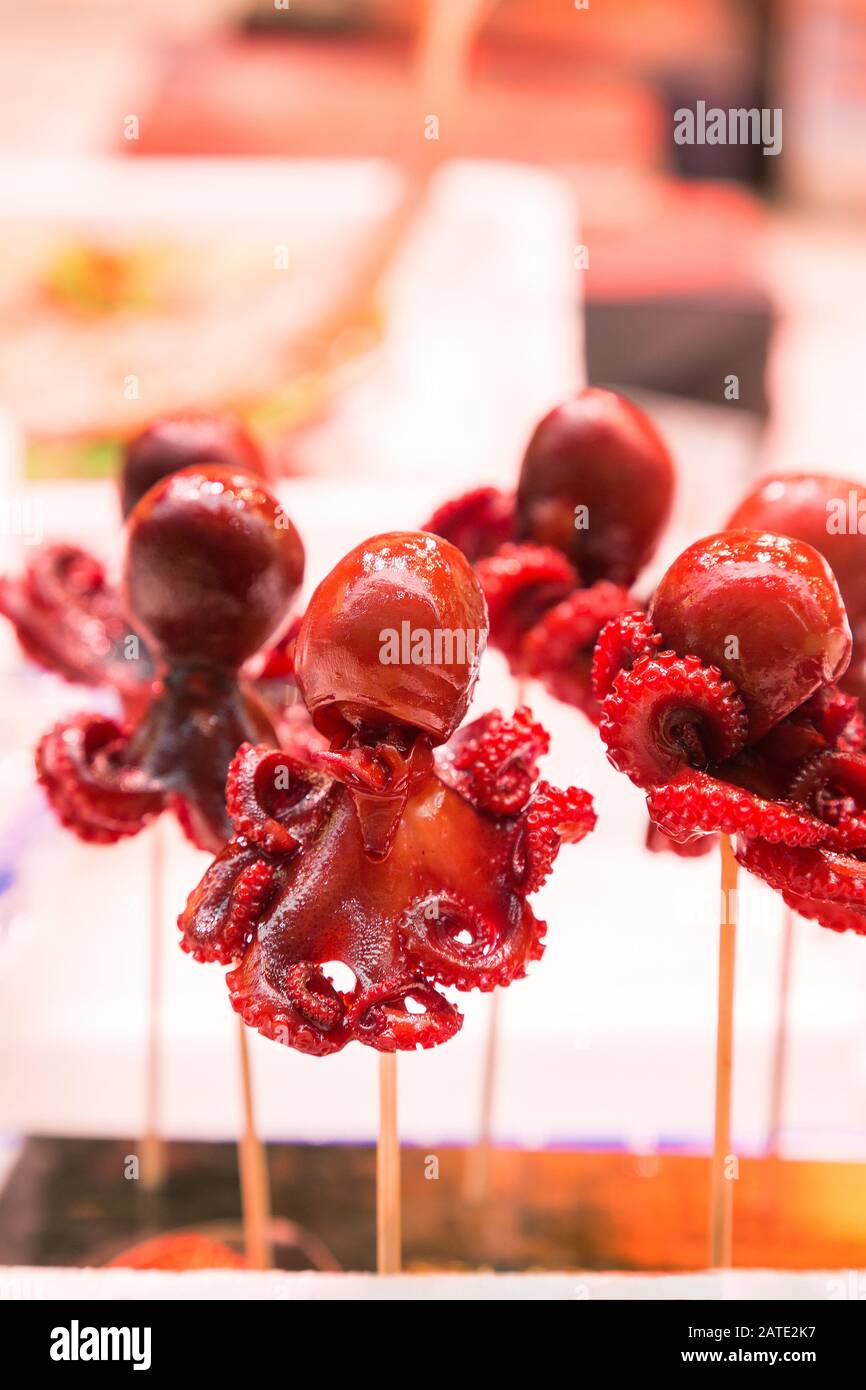 Baby marinated octopus on a stick. Japanese delicacy at a fish market ...