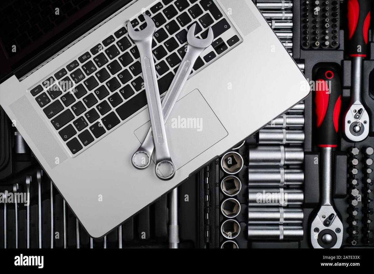 silver chrome wrench and spanner lying on laptop on toolbox with pro ...