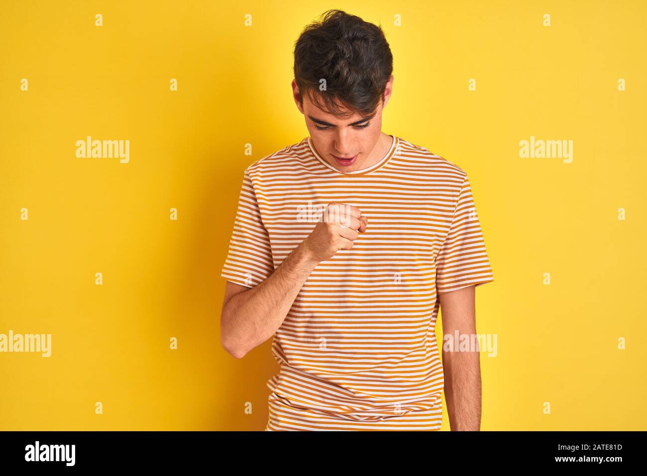 Teenager boy wearing yellow t-shirt over isolated background feeling ...