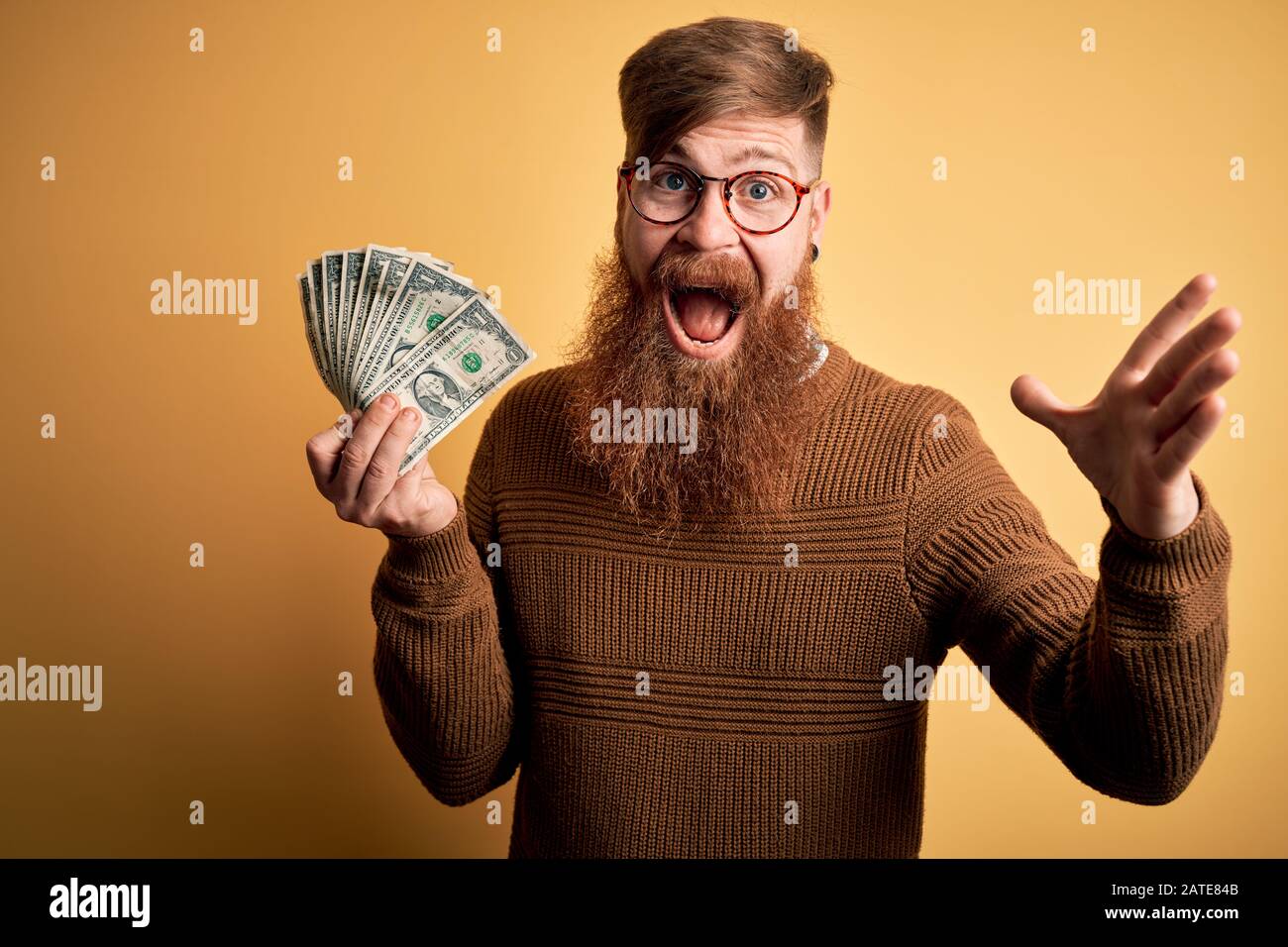 Redhead Irish man with beard holding a bunch of 1 dolla banknotes over ...