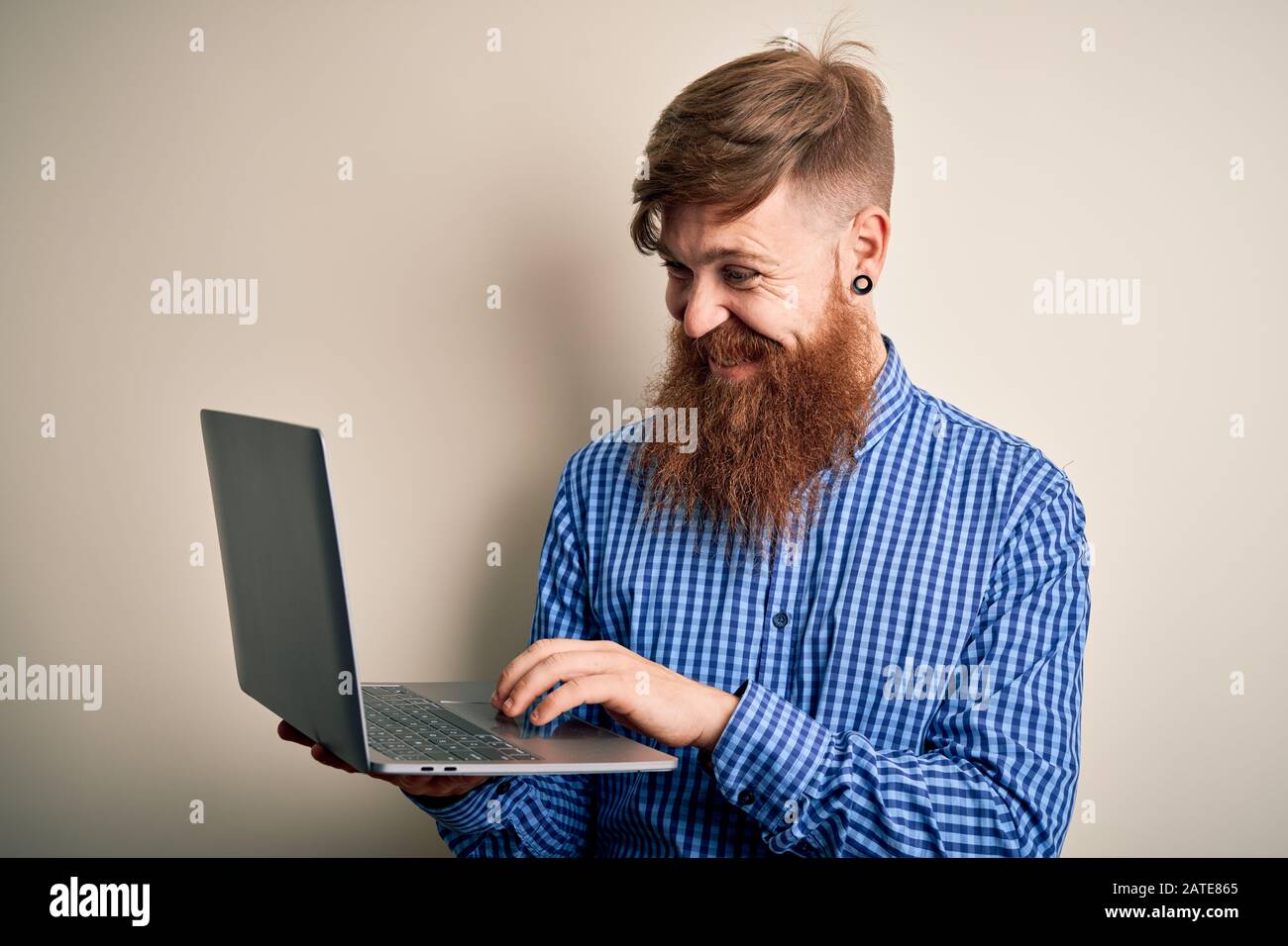 Redhead Irish business man with beard using computer laptop over ...