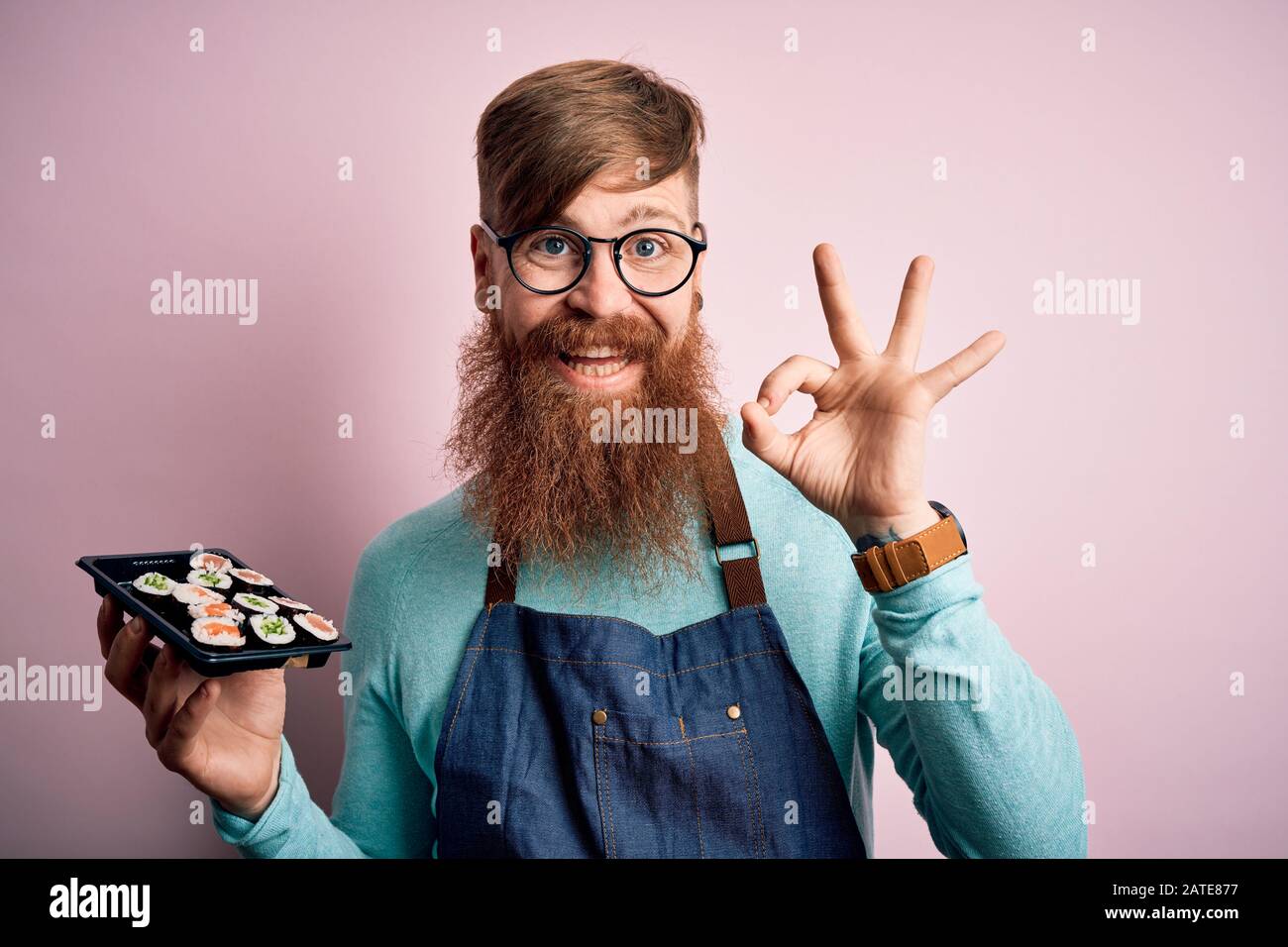 Redhead Irish cook man with beard holding maki sushi tray over isolated ...