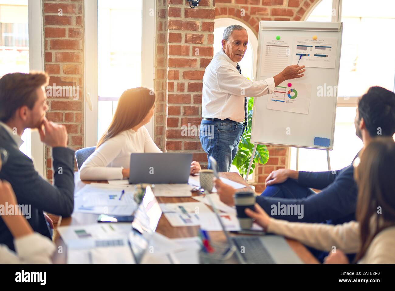 Group of business workers working together in a meeting. One of them ...