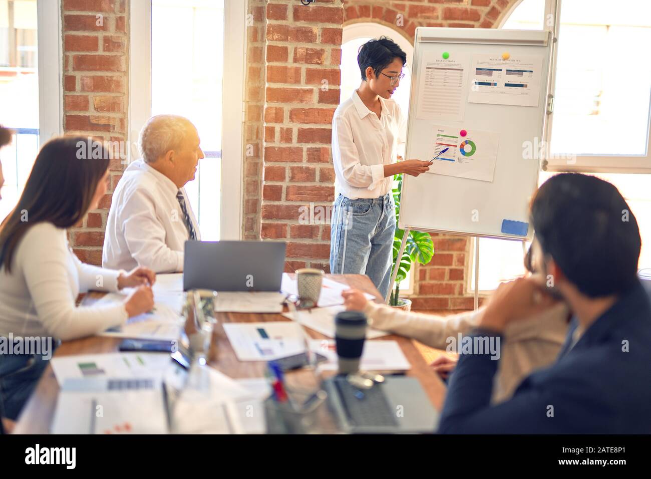Group of business workers working together in a meeting. One of them ...