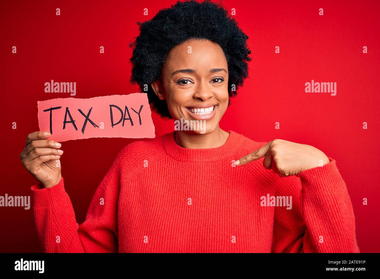 Young African American afro woman with curly hair holding paper with ...
