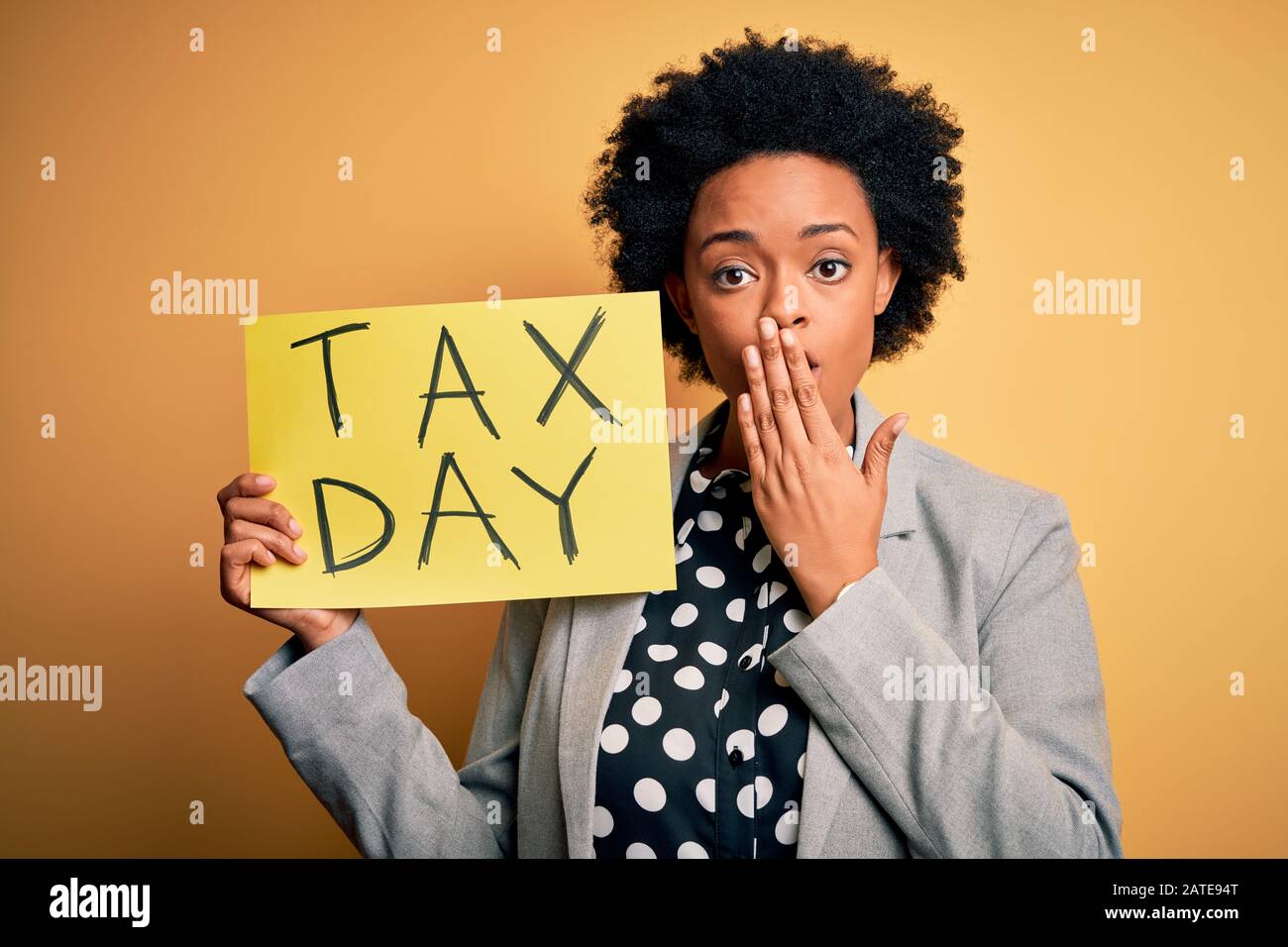 Young African American afro woman with curly hair holding paper with ...