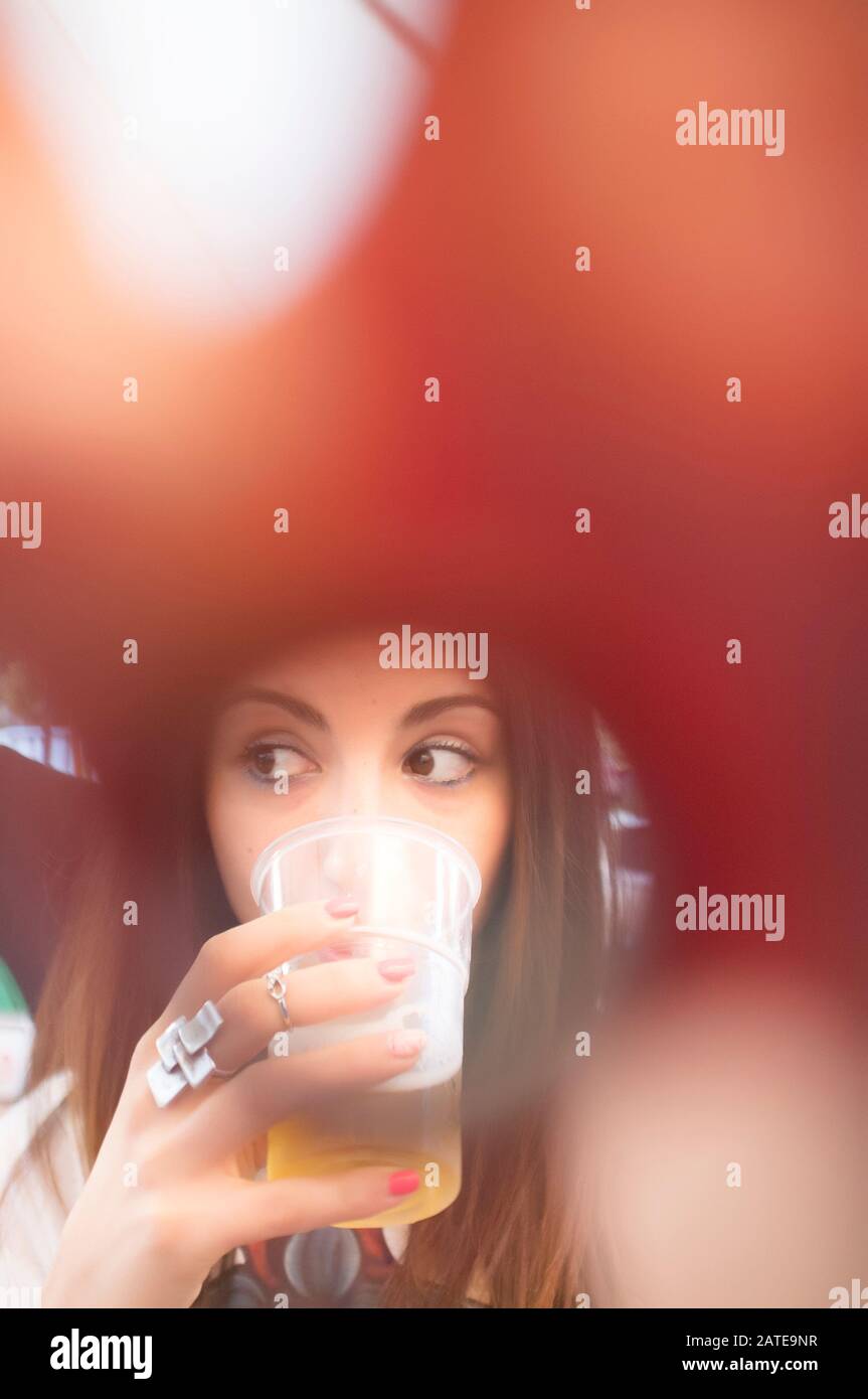 girl drinking beer and looks through the stretched ear lobe Stock Photo ...
