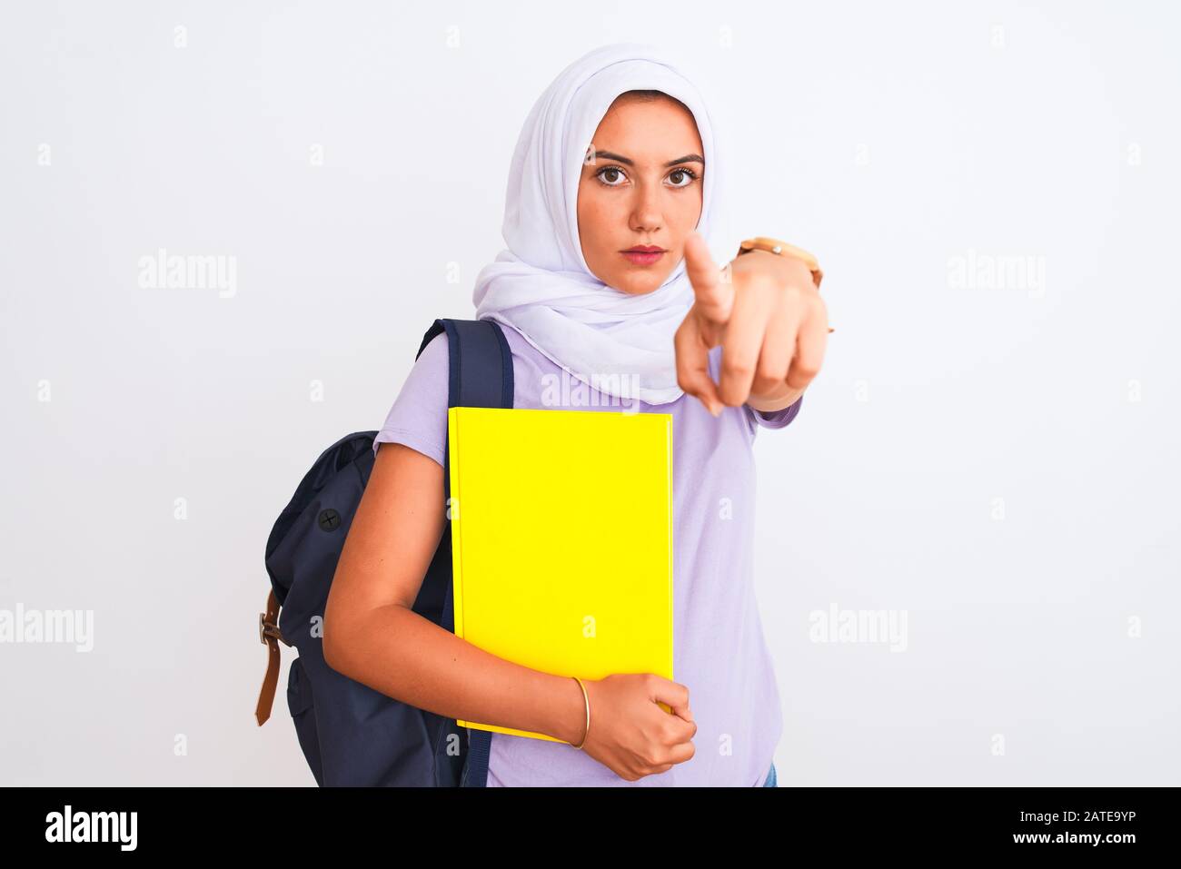 Arab student girl wearing hijab and backpack holding book over isolated ...