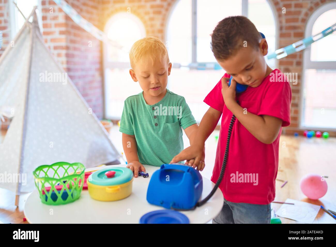 Adorable toddlers playing around lots of toys at kindergarten Stock ...
