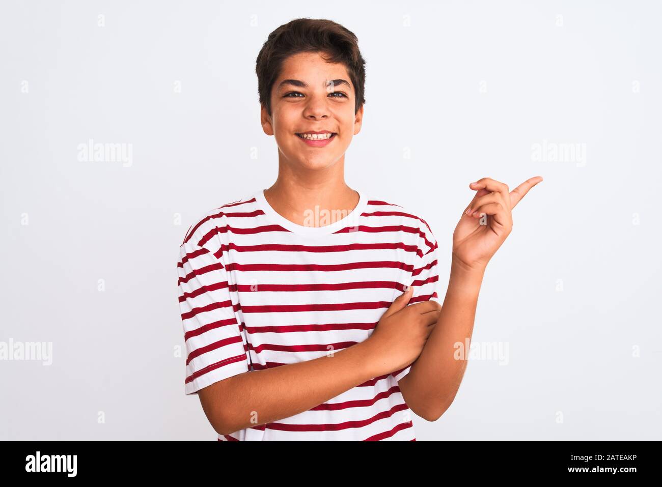 Handsome teenager boy standing over white isolated background with a ...