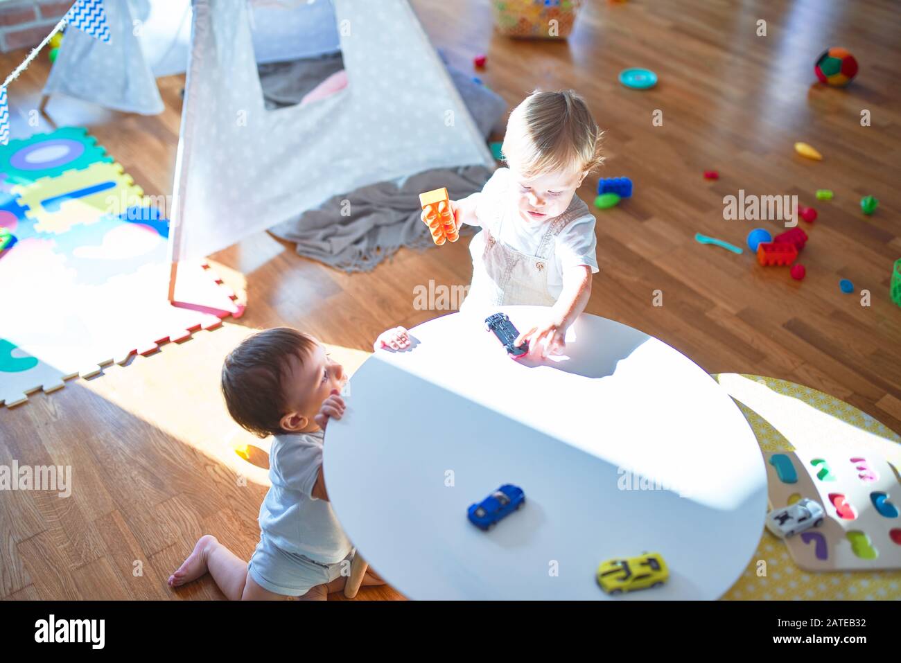 Beautiful toddlers playing around lots of toys at kindergarten Stock ...