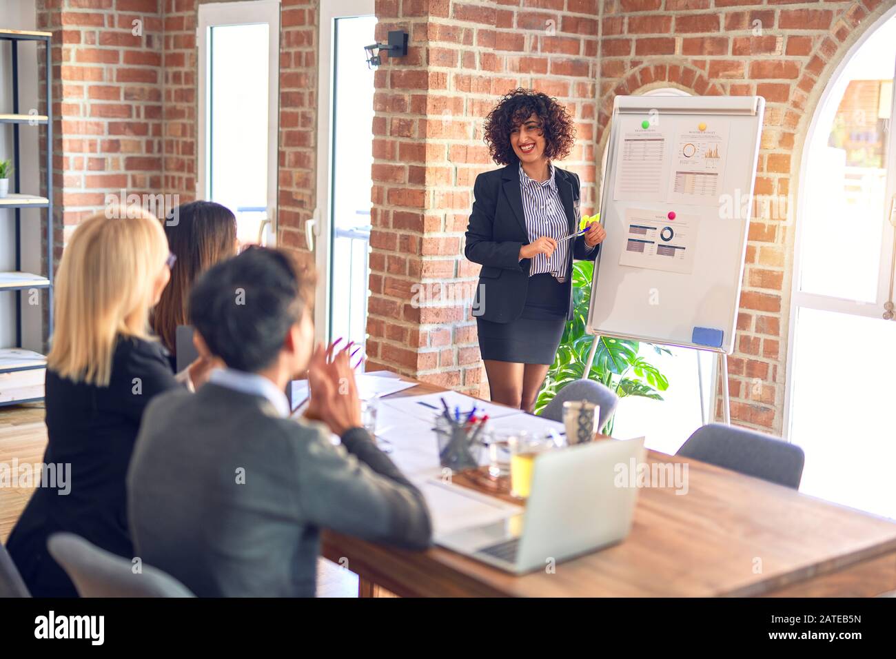 Group of business workers working together in a meeting. One of them ...