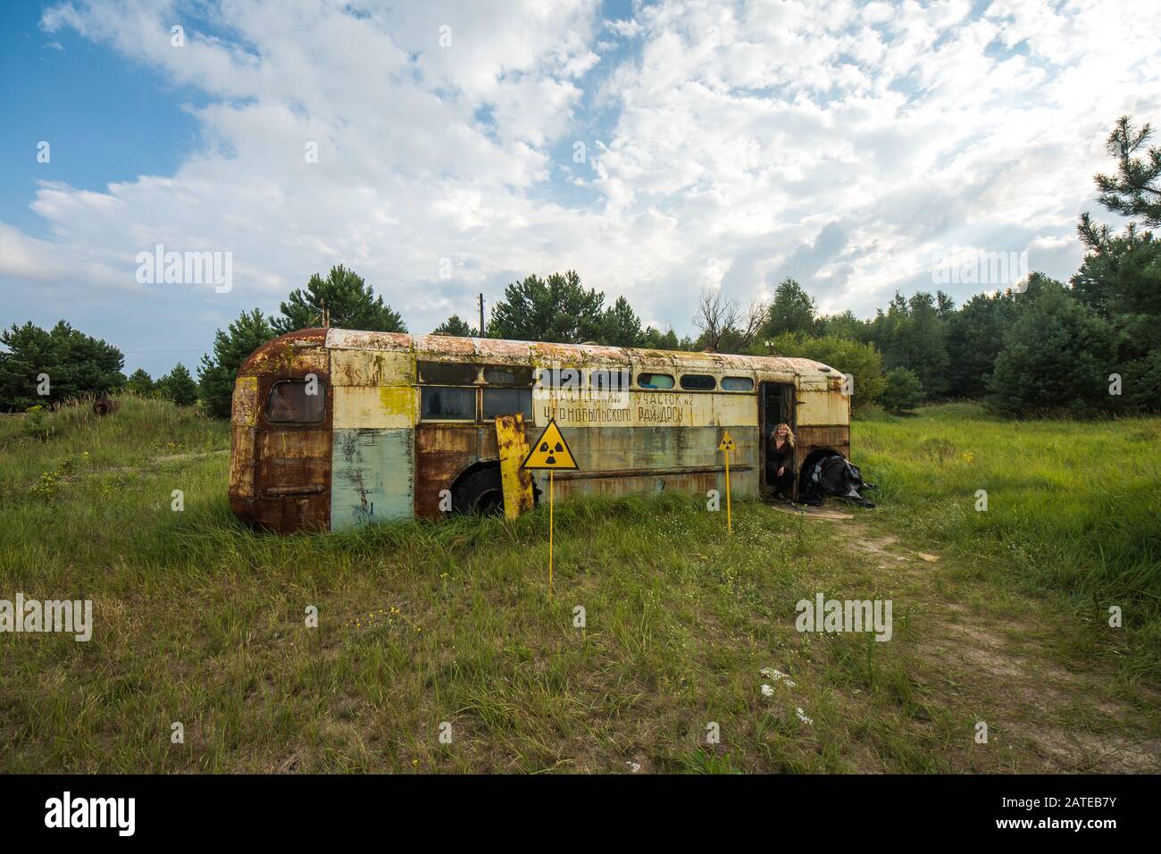 Abandoned and rusty bus in a field in a sunny day with blue sky and ...