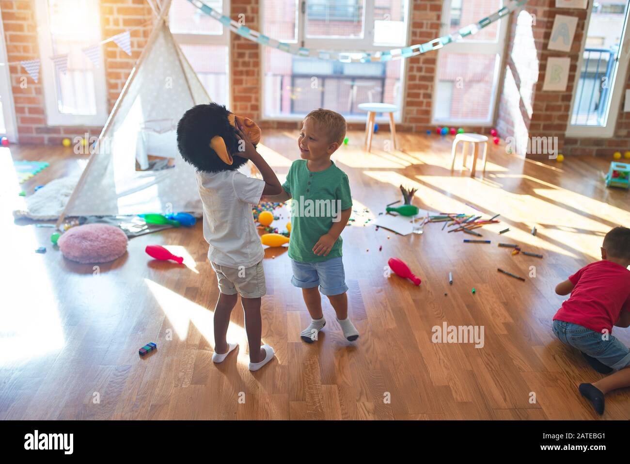 Adorable toddlers playing around lots of toys at kindergarten Stock ...