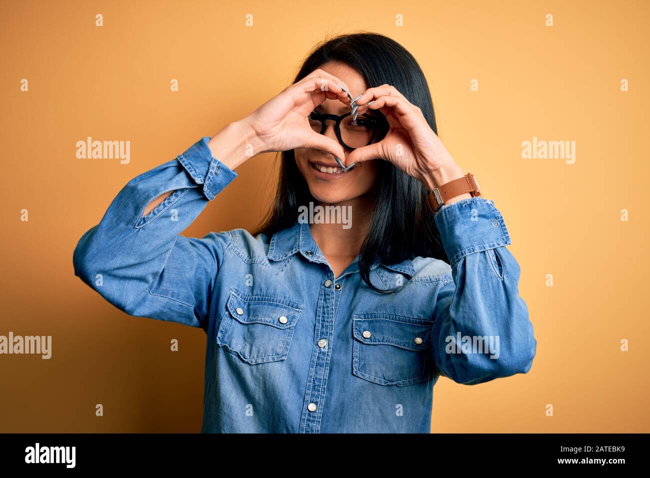 Young beautiful chinese woman wearing casual denim shirt over isolated ...
