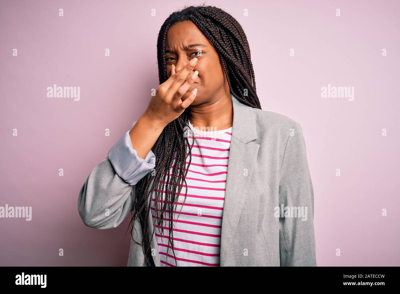 Young african american business woman standing over pink isolated ...