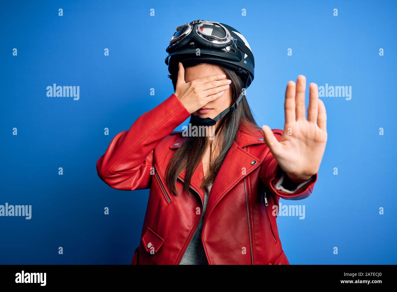 Young beautiful brunette motorcycliste woman wearing motorcycle helmet ...
