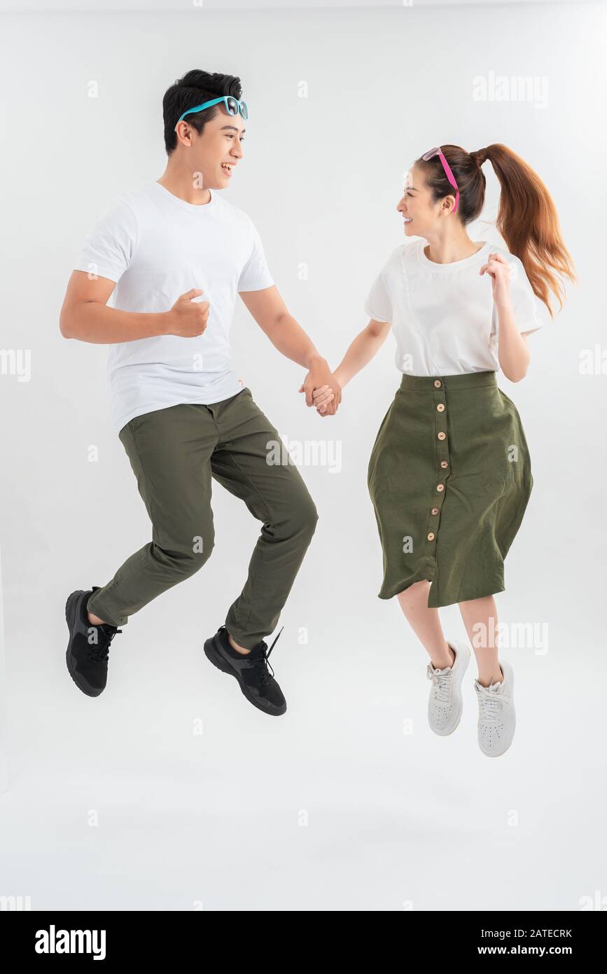 Full length shot of jumping couple having fun together Stock Photo - Alamy