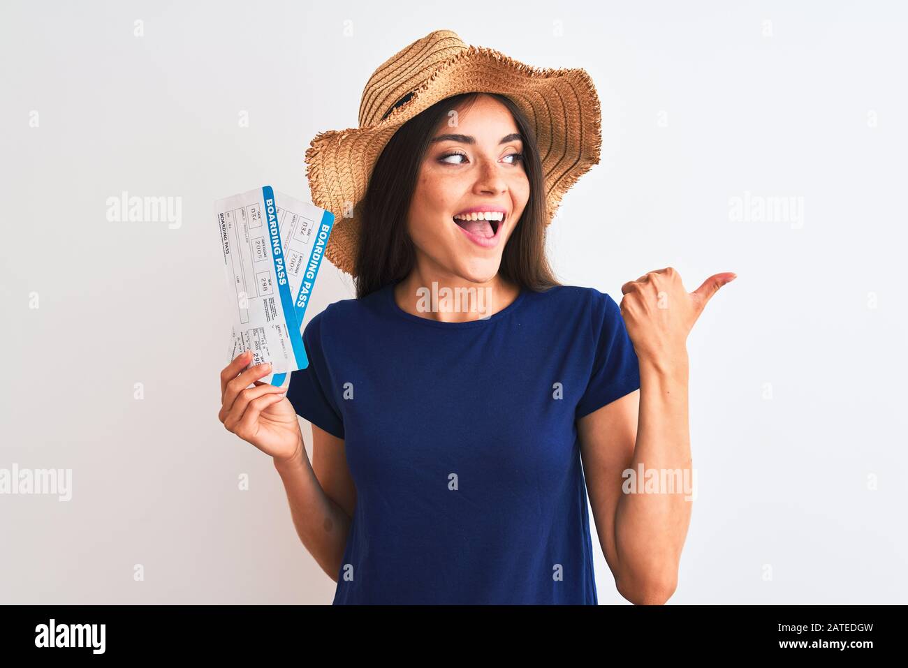 Young beautiful tourist woman holding boarding pass ticket over ...