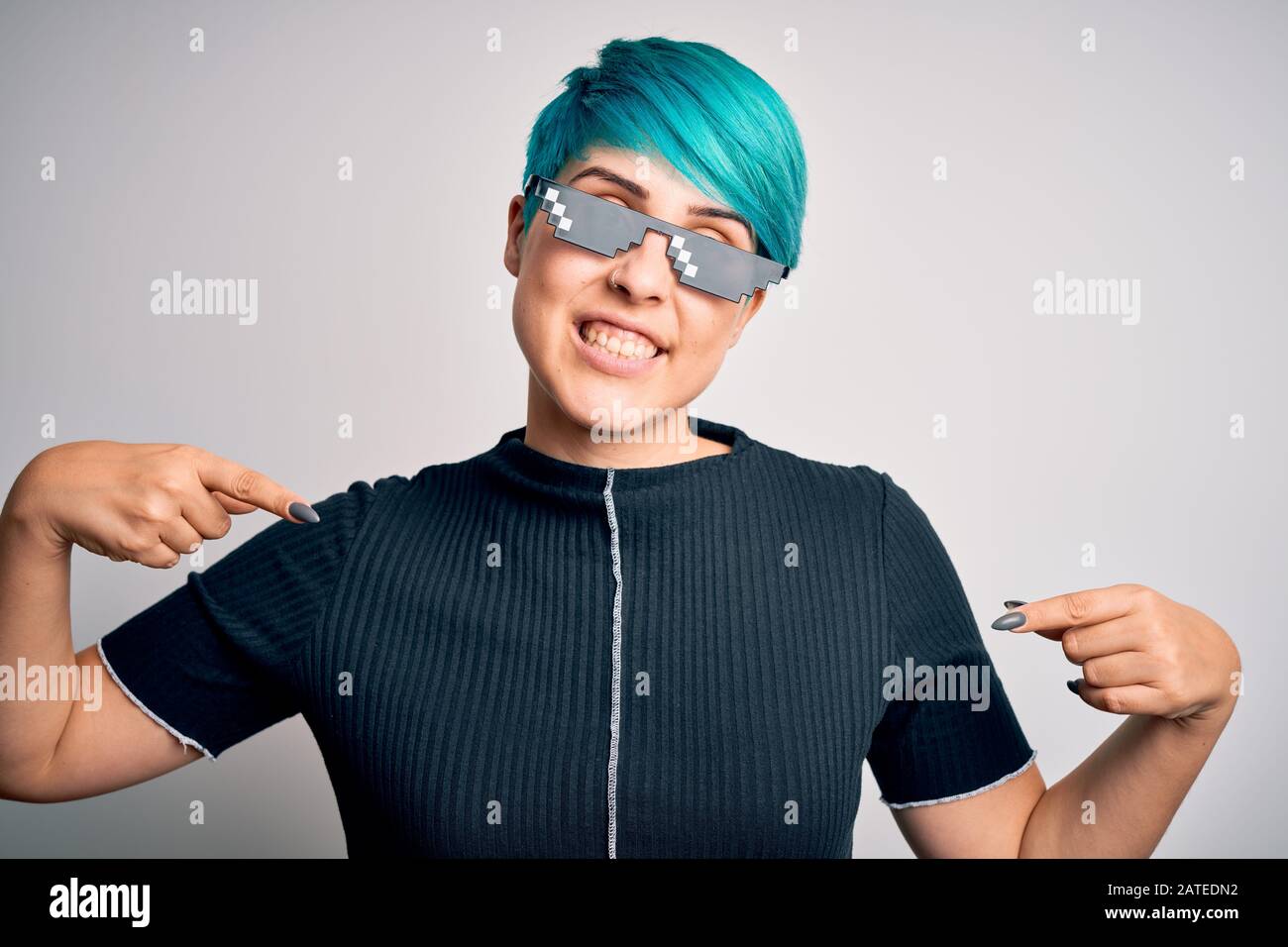 Young woman with blue fashion hair wearing thug life sunglasses over ...