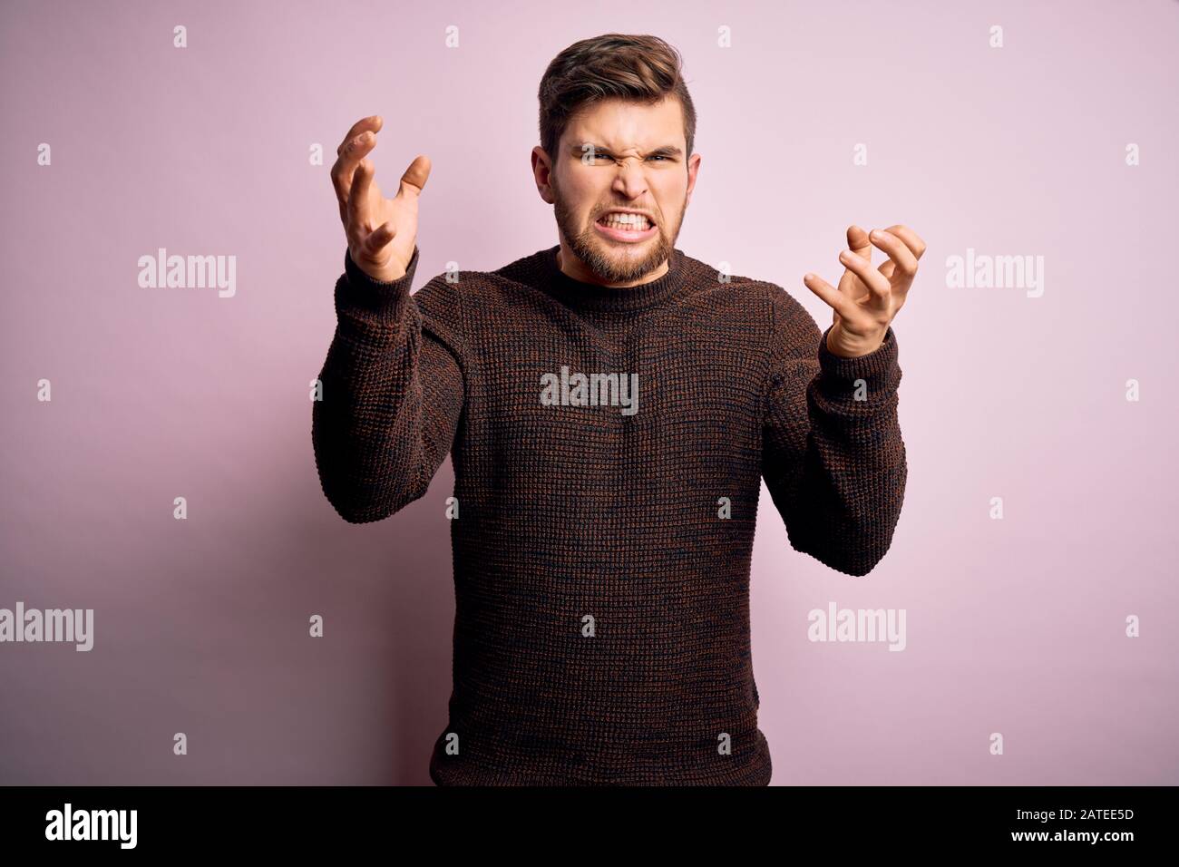 Young blond man with beard and blue eyes wearing casual sweater over ...