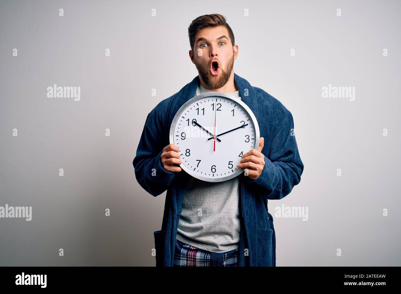 Young blond man with beard and blue eyes wearing pajama holding big ...