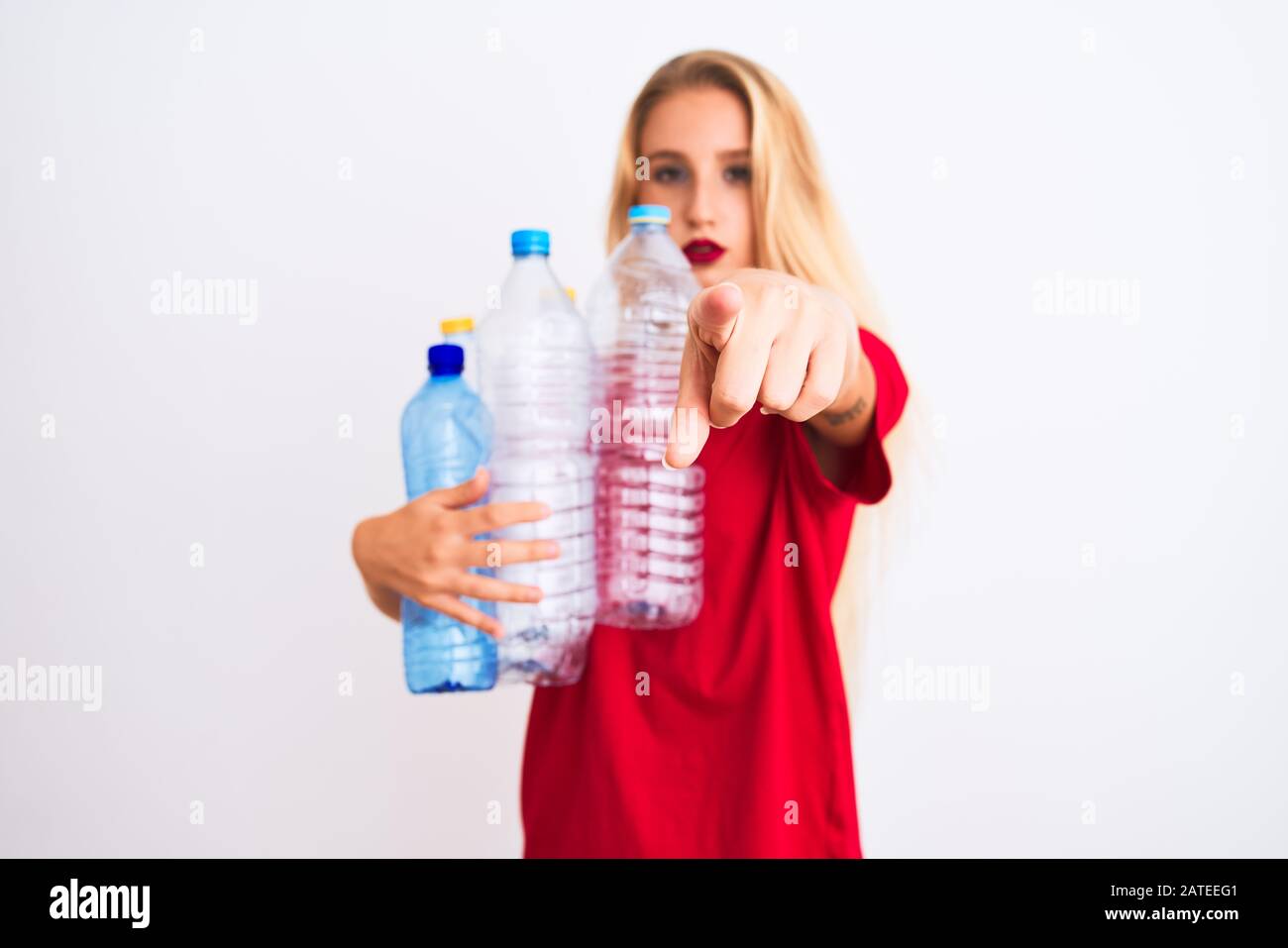 Young beautiful woman recycling plastic bottles standing over isolated ...