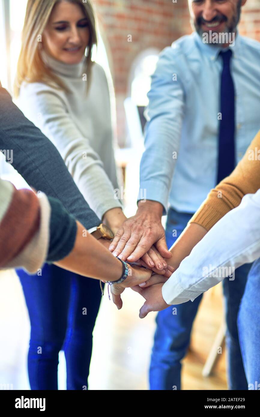 Group of business workers standing with hands together at the office ...