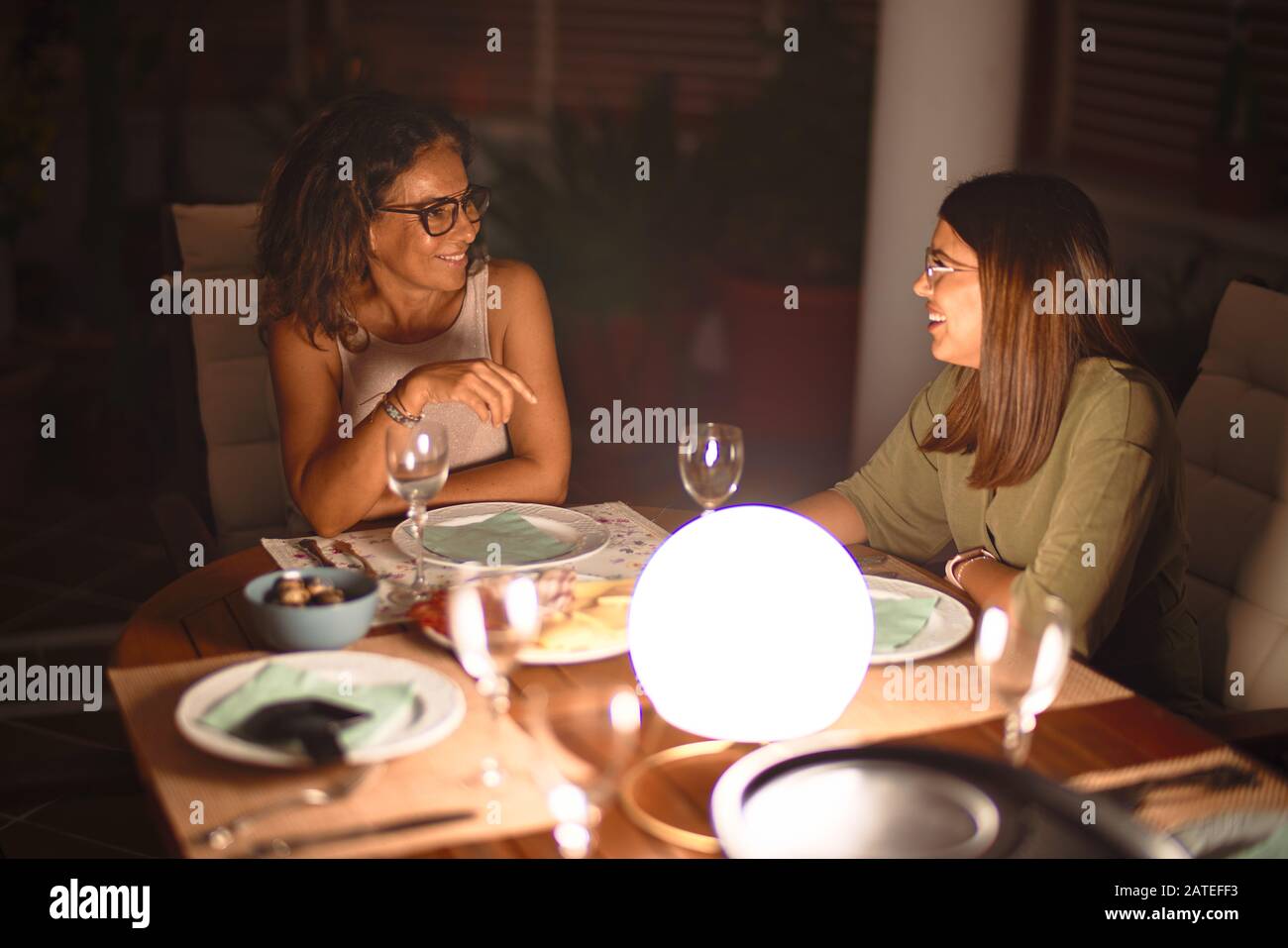 Beautiful mother and daughter on dinner smiling at terrace Stock Photo ...
