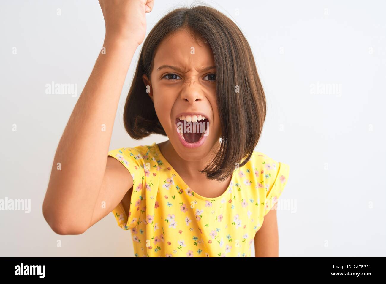 Young beautiful child girl wearing yellow floral dress standing over ...