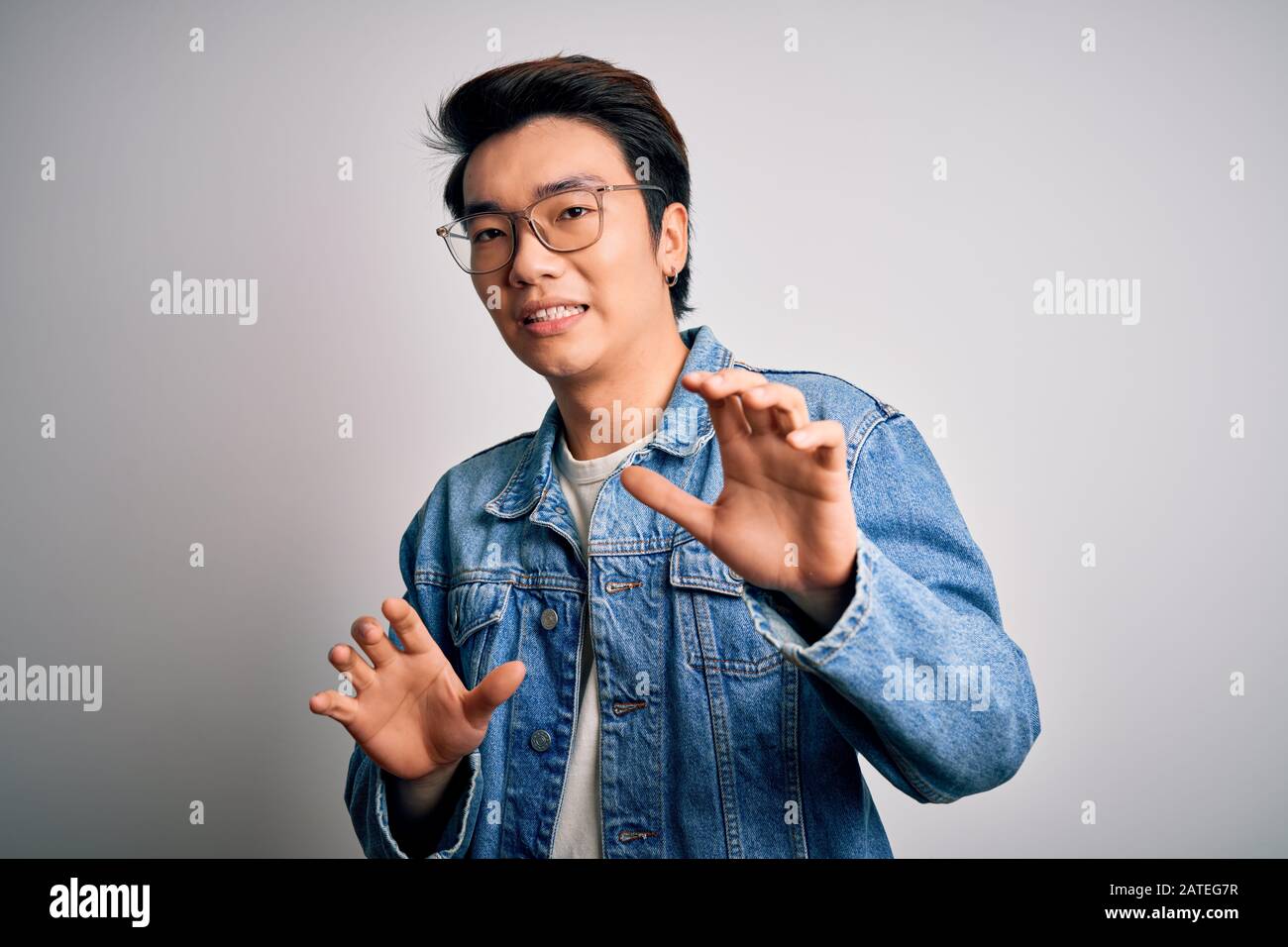 Young handsome chinese man wearing denim jacket and glasses over white ...