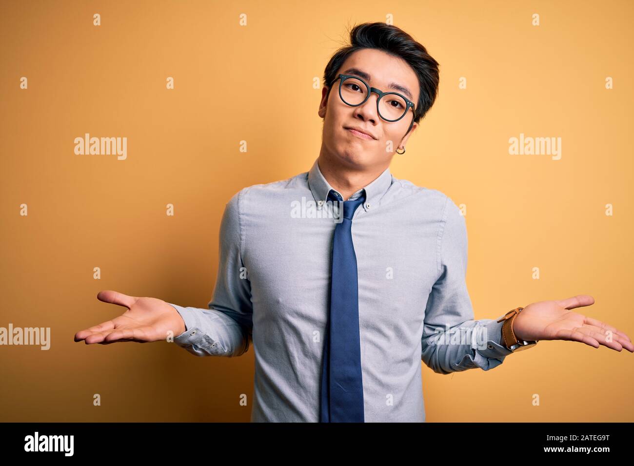 Confused businessman shrugging with raised arms hi-res stock ...
