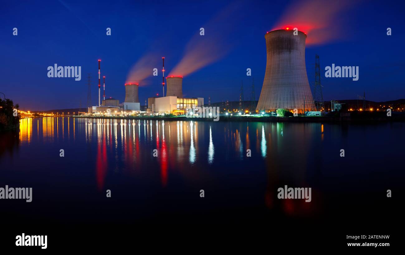 Panoramic night shot of a large nuclear power plant close to a river ...