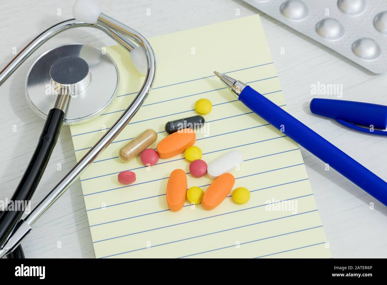 Medical desk. A stethoscope with a sheet of paper, a pen and a handful ...