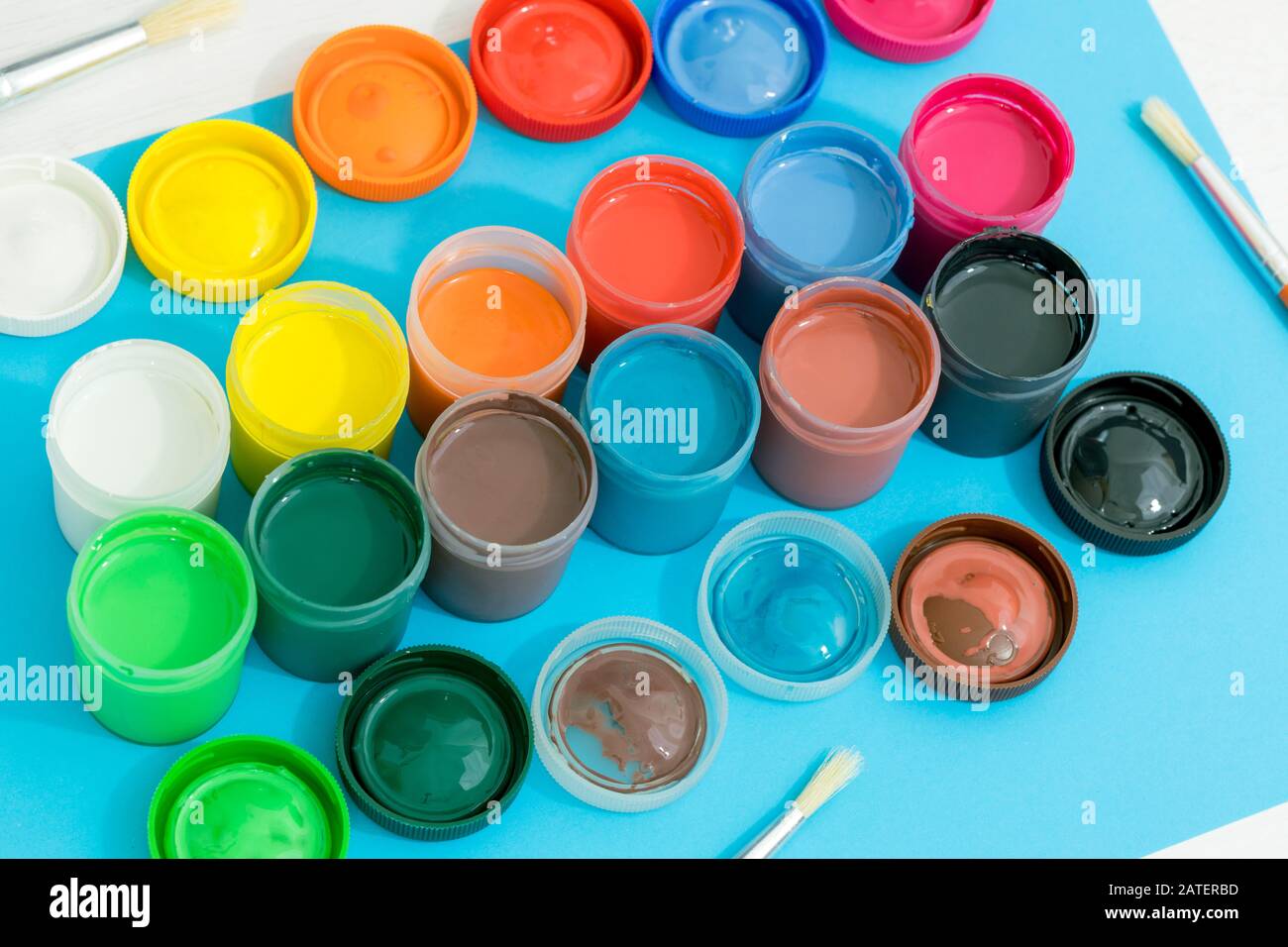 Colorful school paints. Blue background, brushes Stock Photo - Alamy