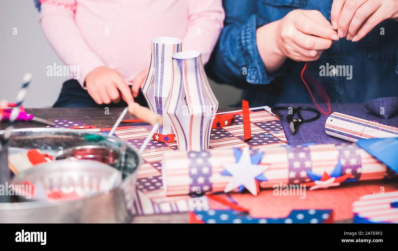 Step by step. Mother and daughter making paper firecrackers for July ...