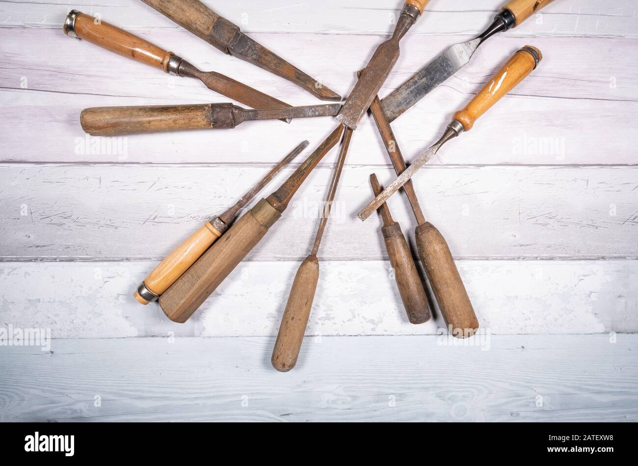 Assortment of old wood chisels on a background of old boards. Top view ...