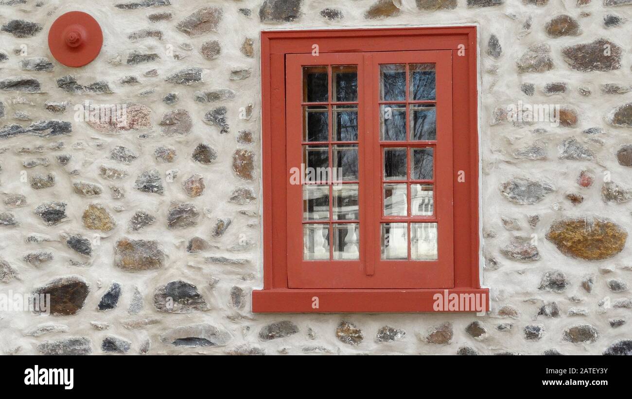 A very old checkered window on a stonewall facade Stock Photo - Alamy