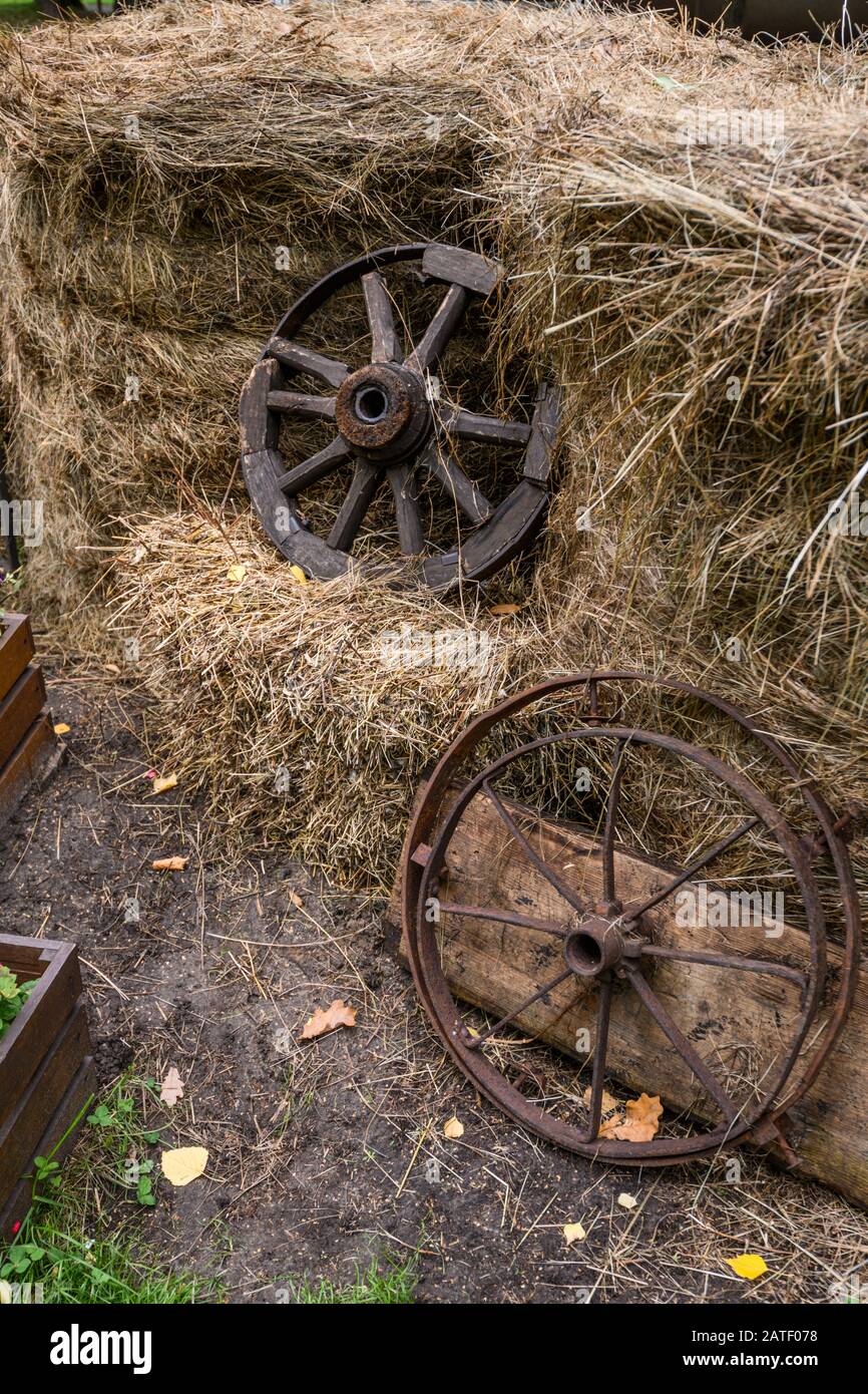 Installation of iron and wooden wheels in hay outdoors Stock Photo - Alamy