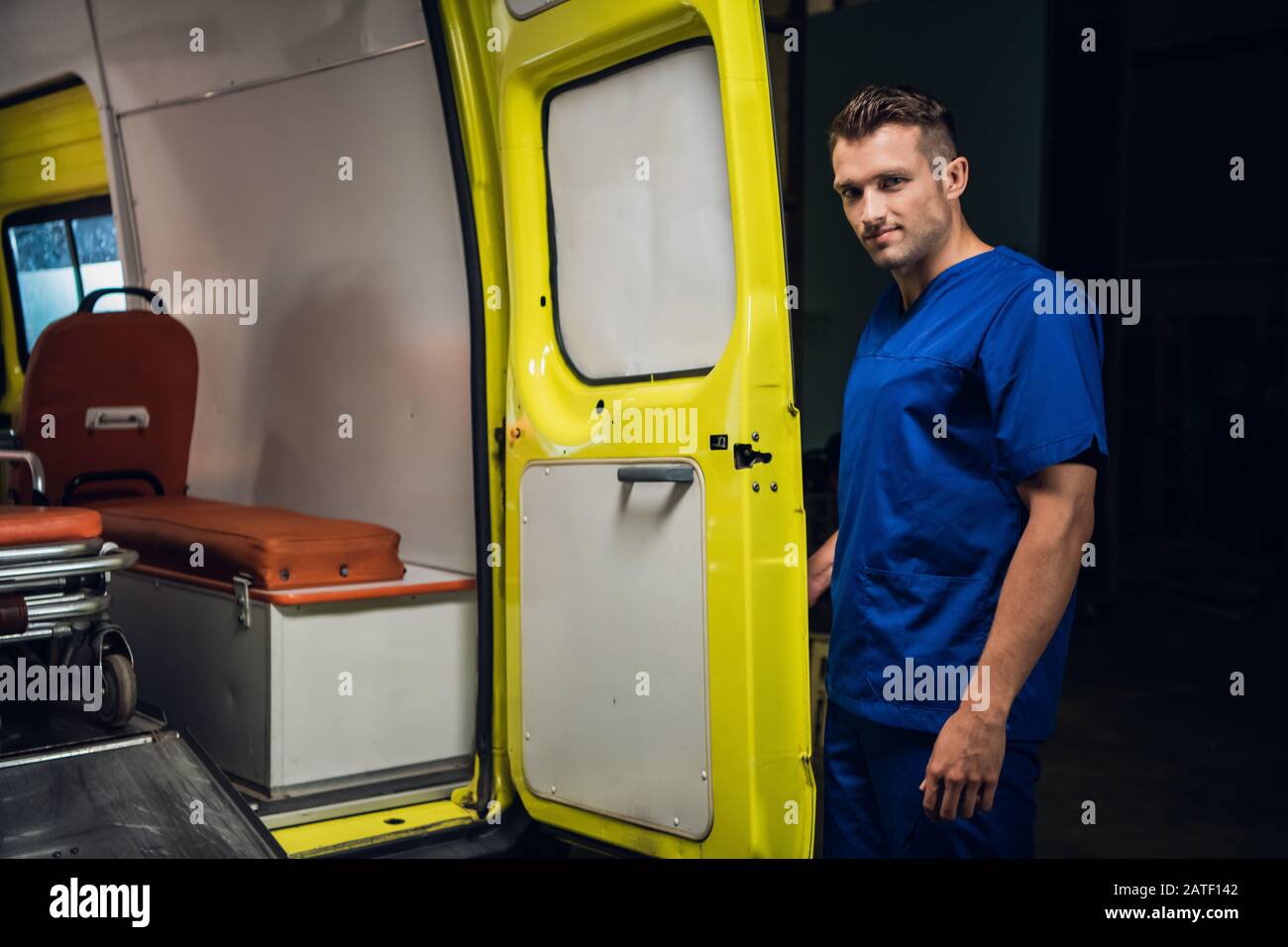 Corpsman in blue medical uniform stands and looks at camera in the ...