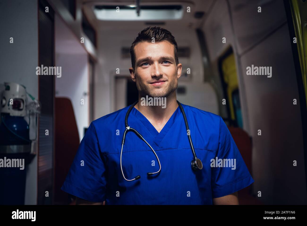 Young corpsman in blue medical uniform stands with smile in the ...