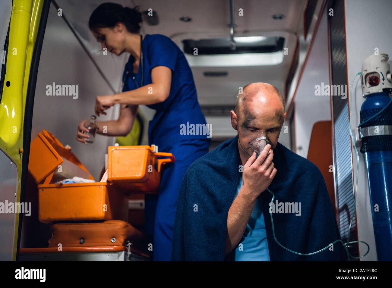 Man breathe through oxygen mask, nurse in medical uniform picks a ...
