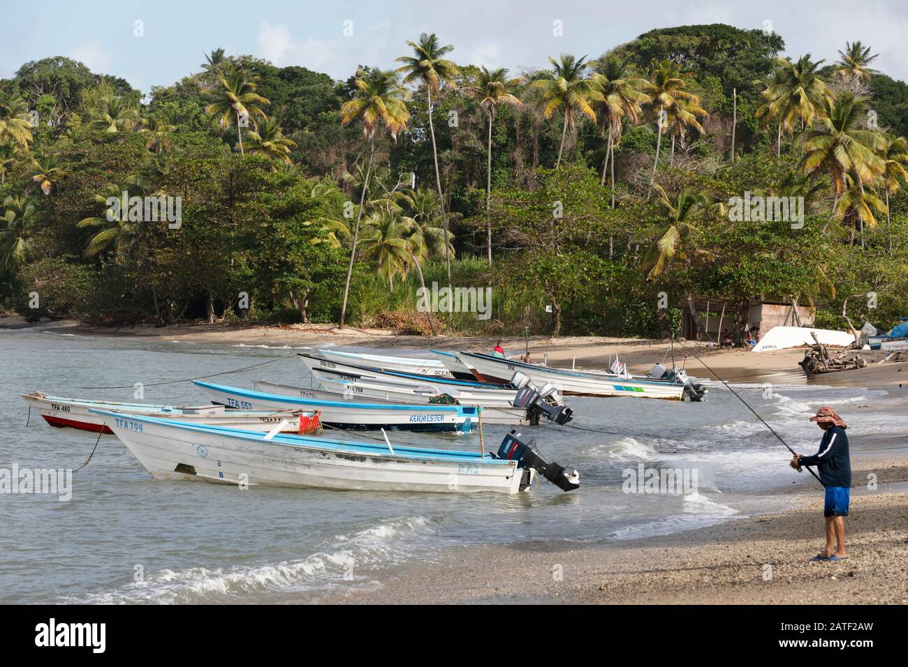 Pirogues and man fishing, Toco, Trinidad & Tobago Stock Photo - Alamy