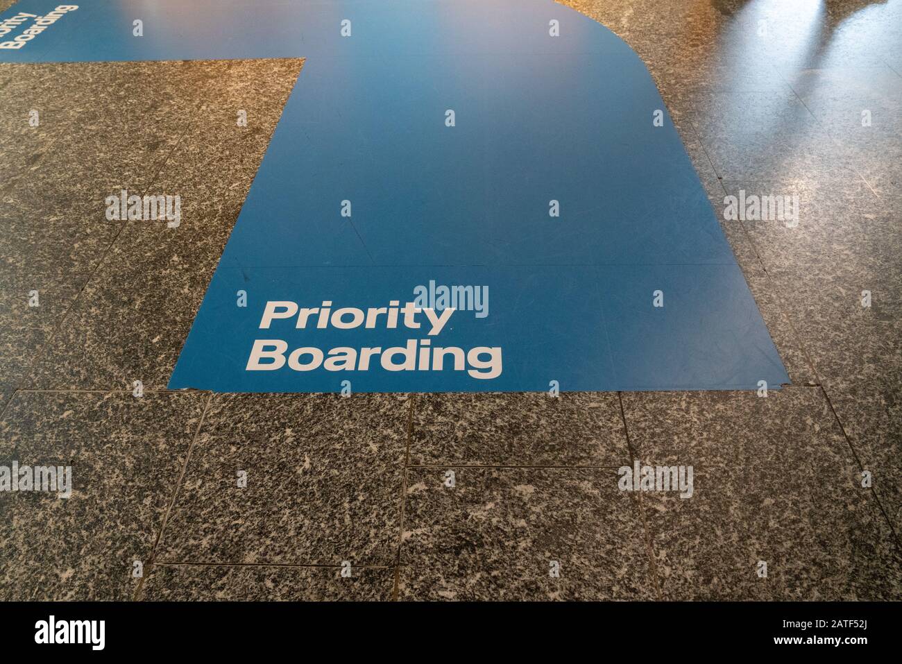 Blue priority boarding lane painted on airport terminal floor leading ...