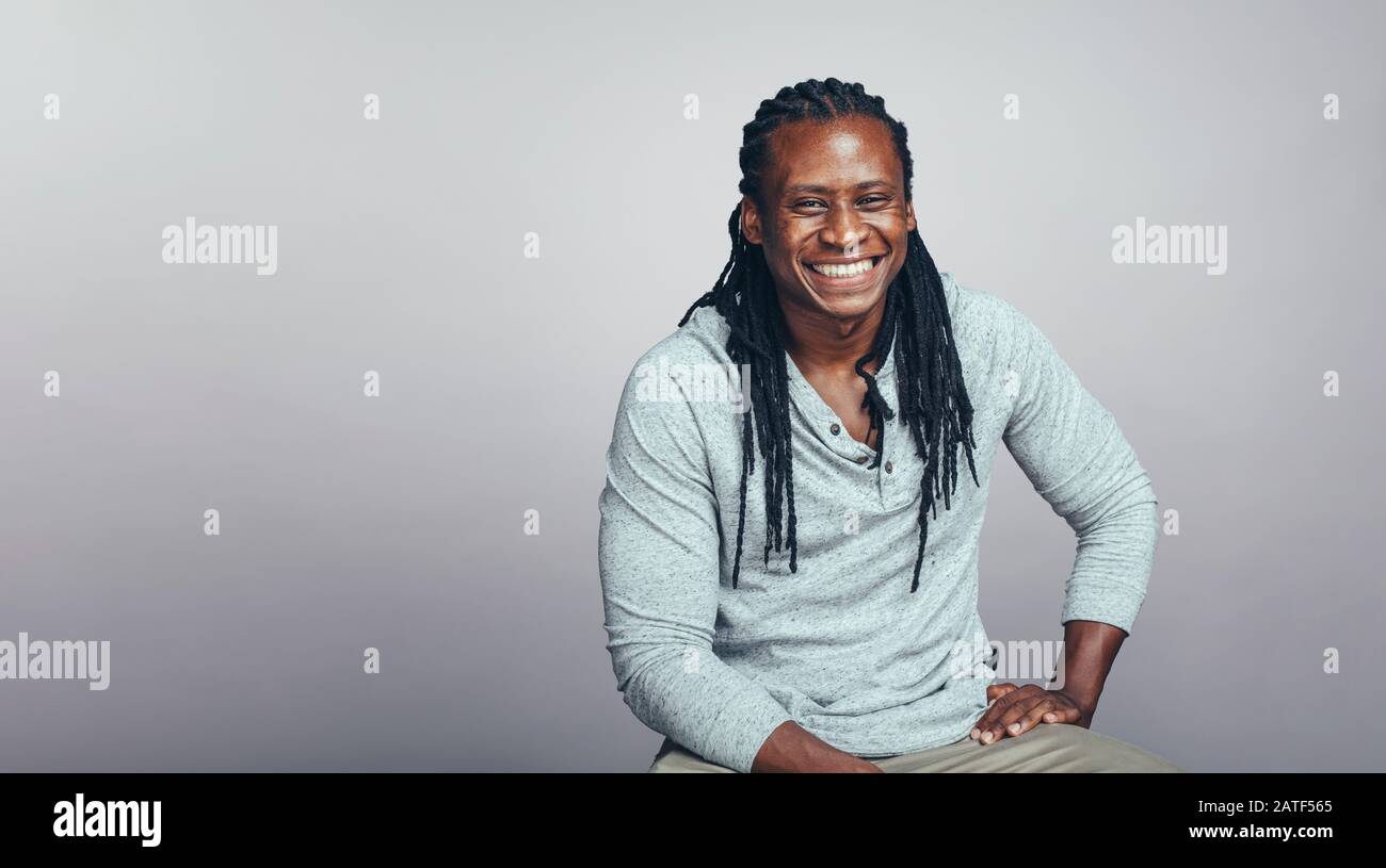 Muscular african male with dreadlocks isolated on grey background ...