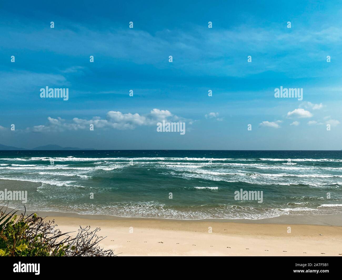 Sandy seashore, calm soft waves at sea, sunny weather, blue sky with ...