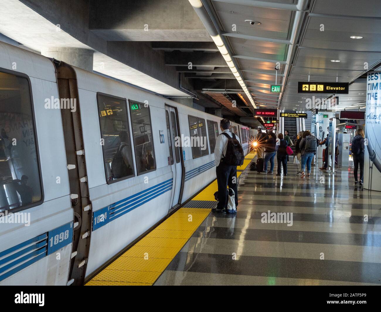 BART bay area rapid transit train with passengers boarding at SFO stop ...