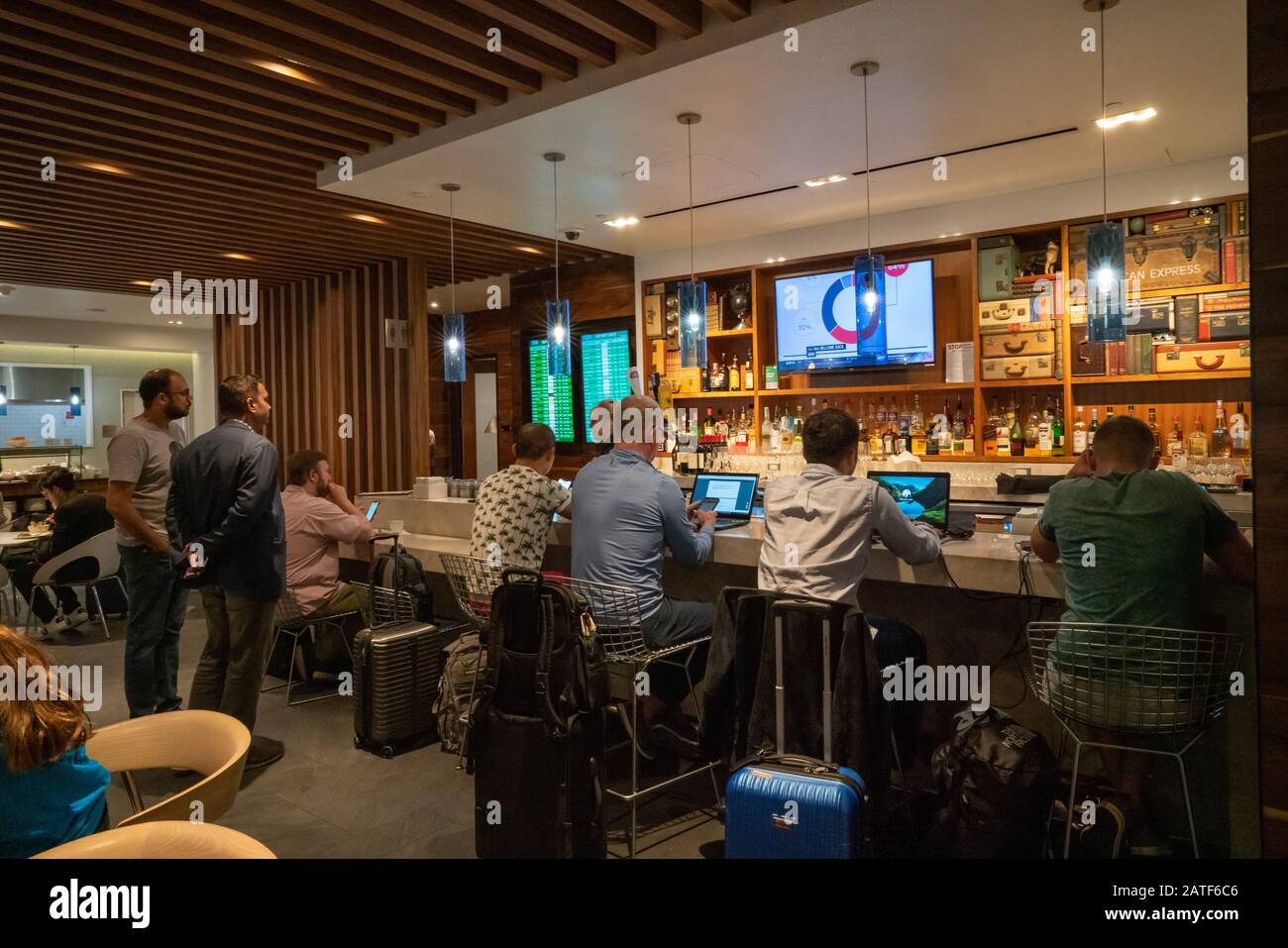 Travelers at an American Express airport lounge bar Stock Photo - Alamy